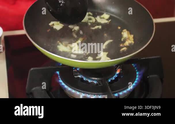 Sauteing Sliced Garlic on Blue Gas Stove Flame Stock Video Footage - Alamy