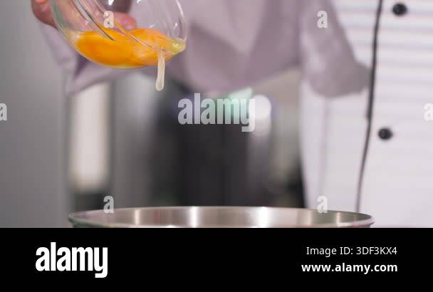 Chef prepares to mix eggs in a bowl. The kitchen is set up for cooking ...