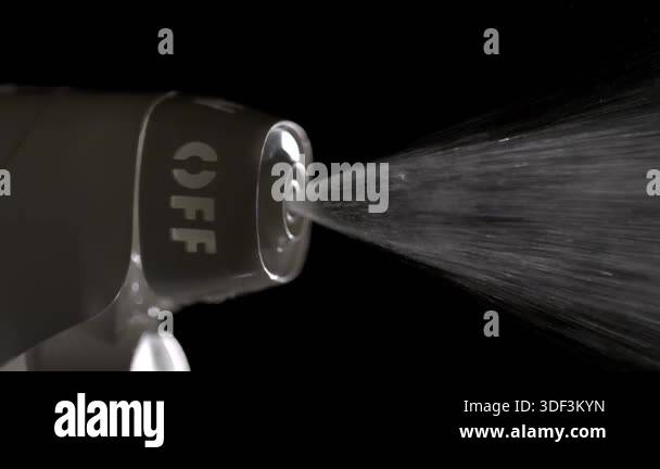 A close-up view shows the spray nozzle in operation, releasing a mist ...