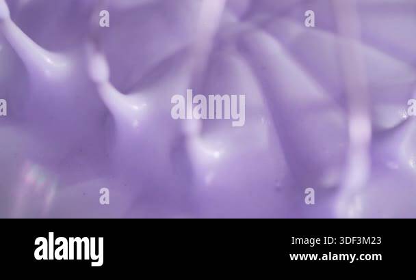 A close-up of a smooth mixture being stirred reveals swirling colors ...