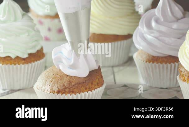 Sweet treats are decorated with colorful icing. A piping bag is used to ...