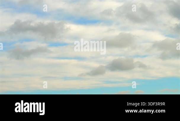 Clouds drift in the sky during sunset. The sunlight creates different ...