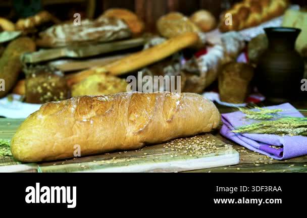 A long loaf of bread is placed on a wooden board surrounded by ...