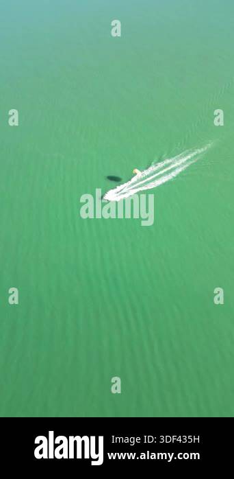 Vertical drone parasailing over green water. 4K vertical footage shows ...