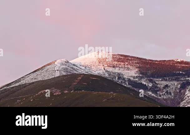 Time-lapse sunset colorful pink and purple sky at dusk over a snowy ...