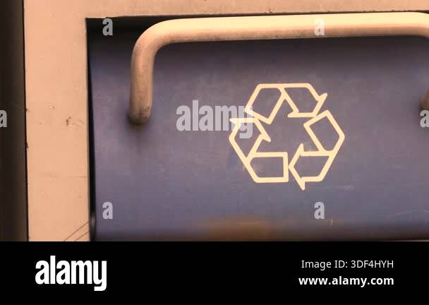 Recycling symbol on metal handled waste bin representing eco friendly ...