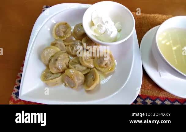 Portion plate with Russian pelmeni served with vinegar and sour cream ...