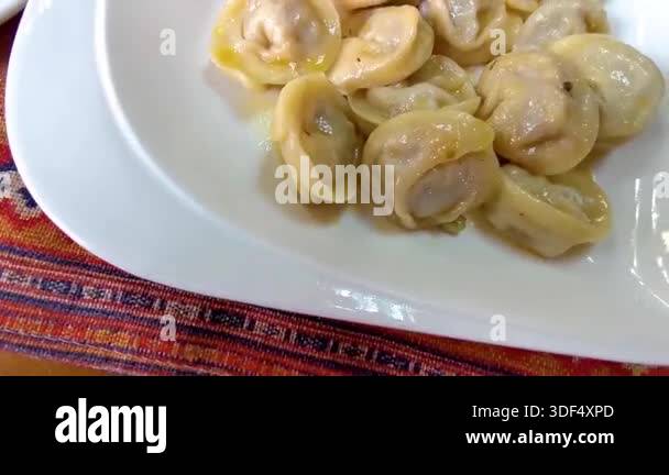 Portion plate with Russian pelmeni served with vinegar and sour cream ...