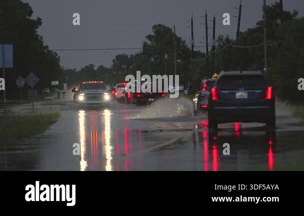 Storm aftermath in Florida. Waterlogged roads with slow moving vehicles ...