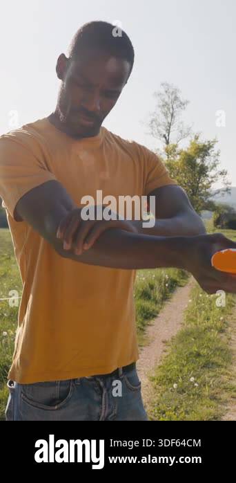 Man applying sunscreen before sun exposure on a walk in nature ...