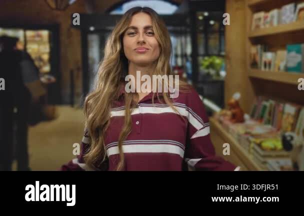 Young blonde woman shapes lips into fish face gesture in a crowded shop ...