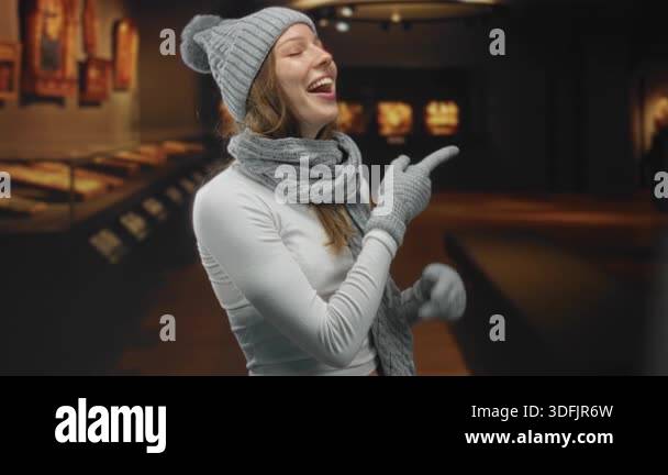 Woman smiling and pointing finger at museum exhibit in building with ...