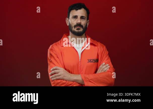 Hispanic man with a beard wearing an orange prison jumpsuit stands ...