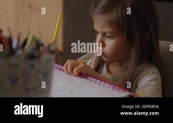 side profile caucasian girl drawing pencil in hand, pot of supplies on ...
