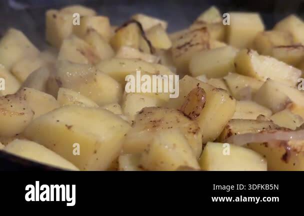 Close-up of fried potato cubes with a golden crust, spices, and ...