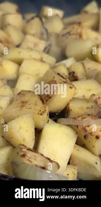 Close-up of fried potato cubes with a golden crust, spices, and ...