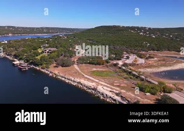 High aerial orbit shot of Windy Point peninsula on Lake Travis on a ...