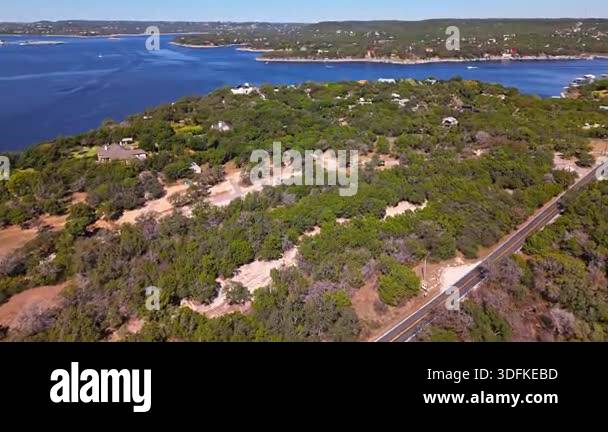 High aerial flyover of Windy Point peninsula on Lake Travis on a sunny ...
