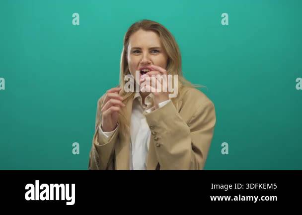 Woman with blonde hair in a beige suit appears scared, posing against a ...