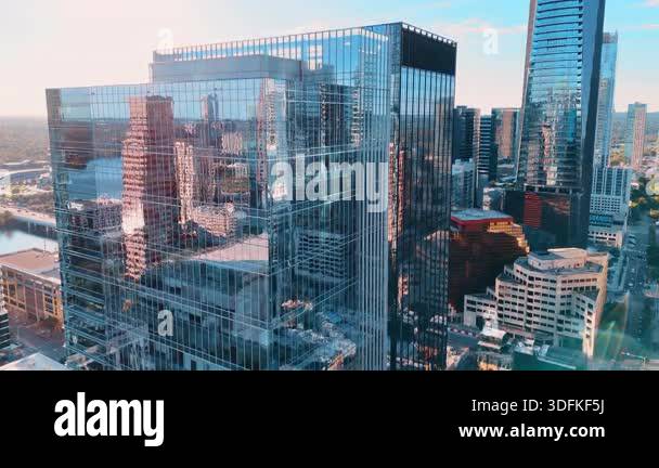 Rising along amazing high-rise glass buildings reflecting the cityscape ...