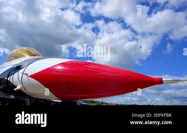 Close-up of a military fighter jet nose with red and white paint under ...