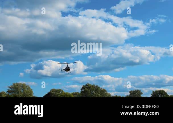 Helicopter flies across the sky, banking slightly as it passes through ...