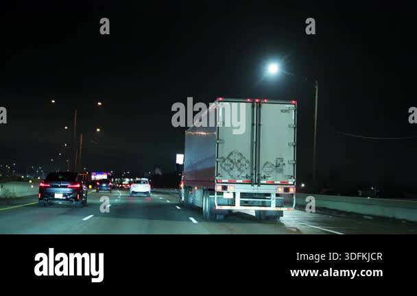 Semi-truck with 53-foot dry van semi-trailer traveling on illuminated ...