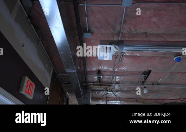 View of unfinished commercial interior ceiling with exposed HVAC ducts ...