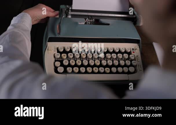 Close-up of vintage typewriter and hands typing, inserting paper, and ...