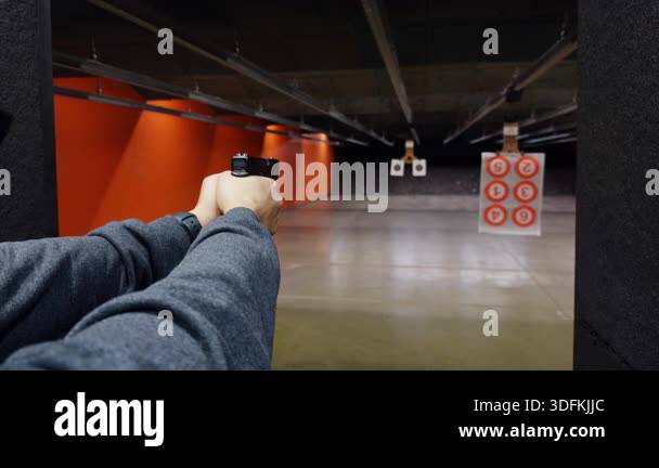 POV of person actively shooting a handgun at paper targets inside an ...