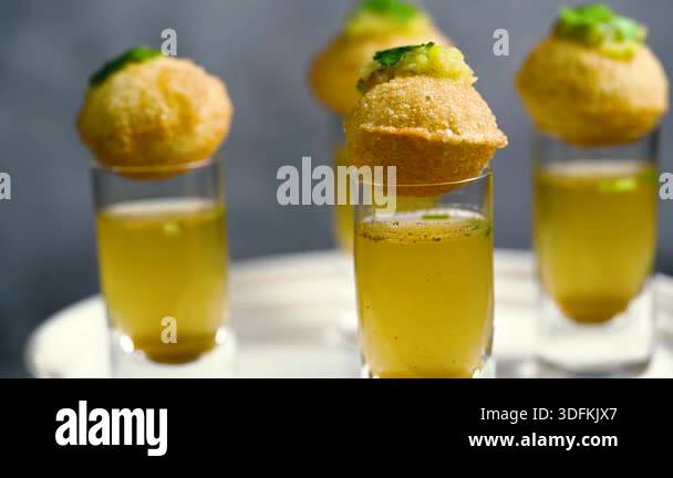Close up of Indian street food fuchka on a glass with sour spicy water ...