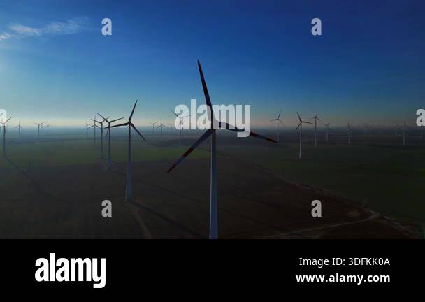 Wind turbines rotating in a vast rural landscape, providing clean ...