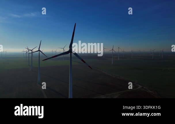 Wind turbines rotating in a vast rural landscape, providing clean ...
