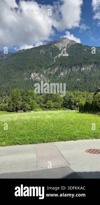 Alpine Meadow Beside Roadside Blue Sky With Towering Mountain Peak ...