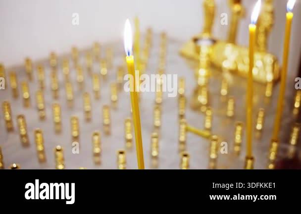 Single Tall Gold Candle Burning Amid Rows Of Empty Gold Holders On ...