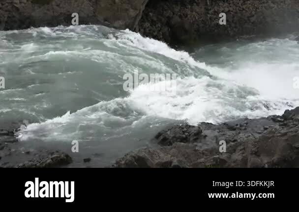 Turbulent river with strong currents and whitewater rapids flows ...