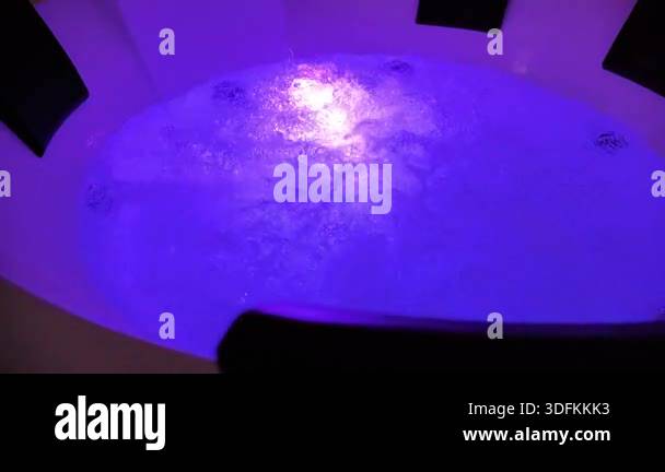 water in a jacuzzi .Bubbling water in a jacuzzi in purple light. Spa ...