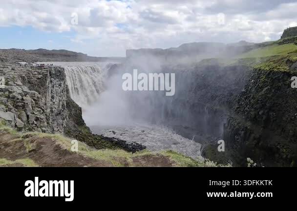 Majestic Gullfoss waterfall roaring down a rugged canyon under a cloudy ...
