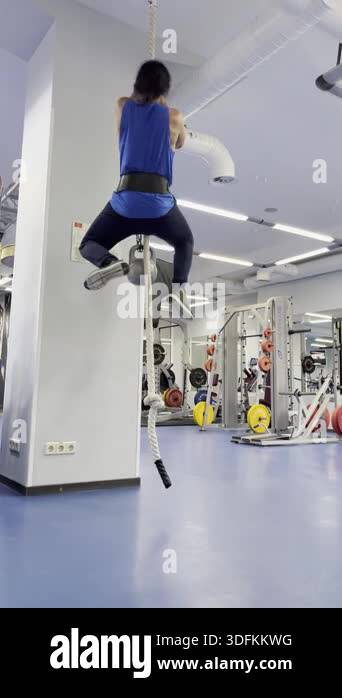 Athlete Climbing Rope In Gym, Focused Rope Ascent For Upper Body ...