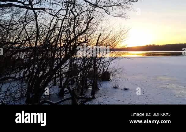 Picturesque view of a snow covered frozen lake reflecting the golden ...