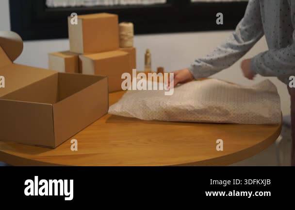 A seller neatly folds a high-quality second-hand sweater into ...