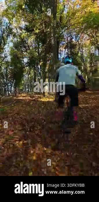 Vertical aerial FPV drone footage of a rider in blue gear navigates a ...