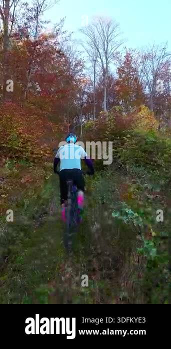 Vertical aerial FPV drone footage of a rider in blue gear navigates a ...