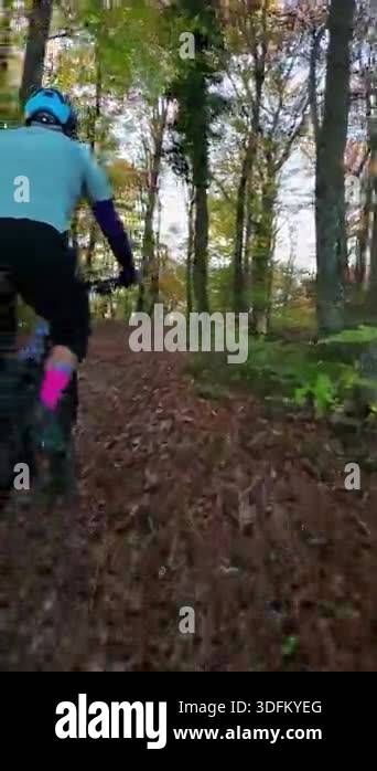 Vertical aerial FPV drone footage of a rider in blue gear navigates a ...