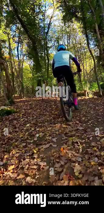 Vertical aerial FPV drone footage of a rider in blue gear navigates a ...