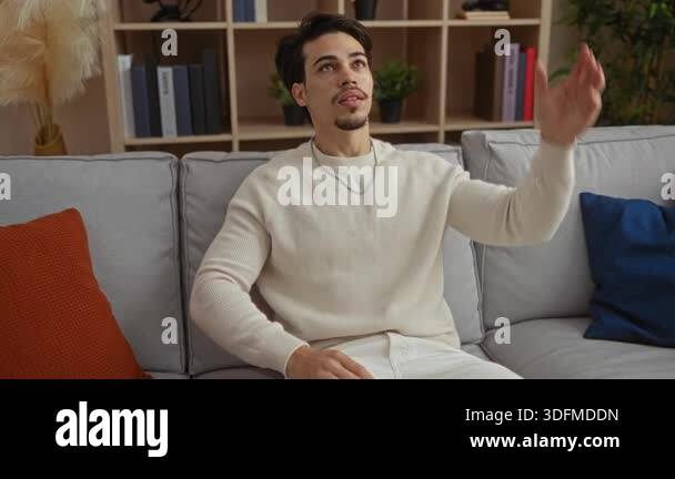 Young man relaxing on a comfortable couch in a modern living room with ...