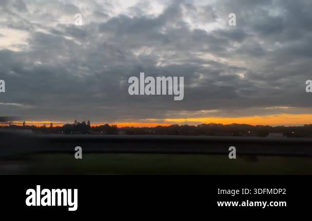 Dramatic sunset landscape with heavy textured clouds over a rural ...