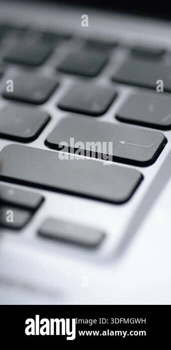 Pressing the Enter key on a silver keyboard. Extreme close-up. Vertical ...