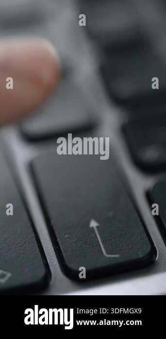 Pressing the Enter key on a black keyboard. Extreme close-up. Vertical ...