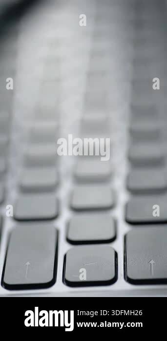 Abstract vertical close-up of a silver laptop keyboard creating a ...